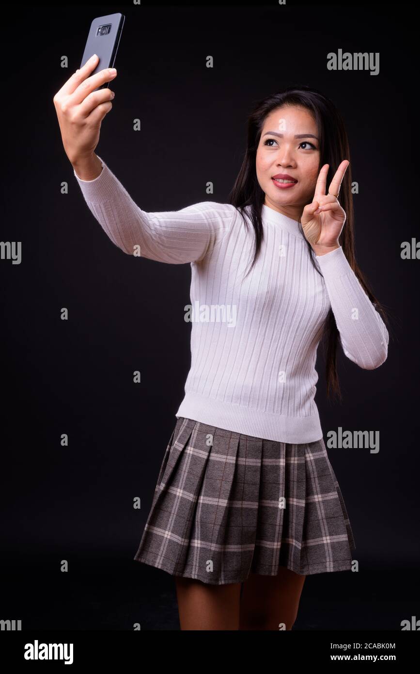 Portrait Of Young Beautiful Asian Woman Against Black Background Stock