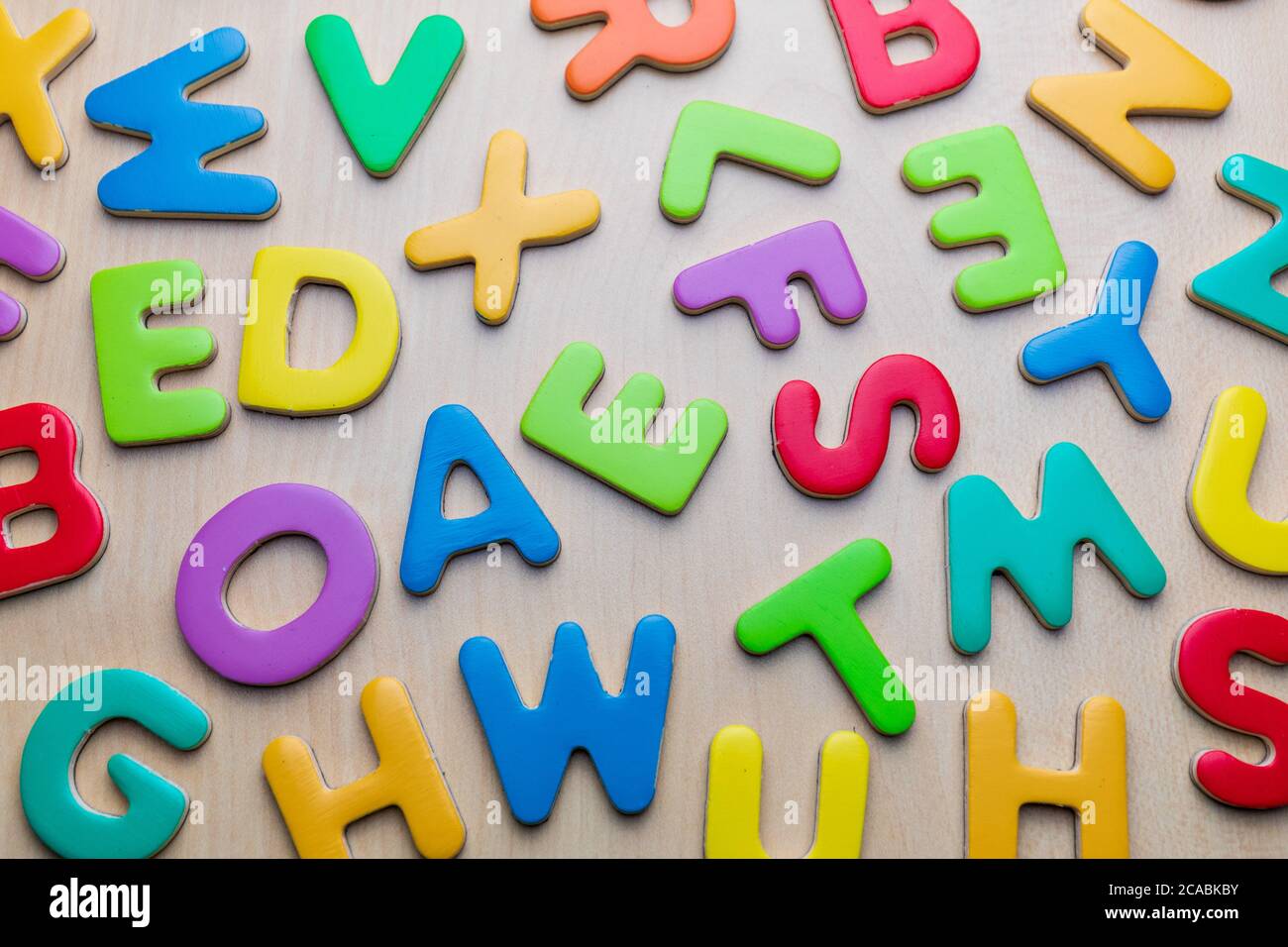 colorful mixed letters pile on a wooden table, top view Stock Photo - Alamy