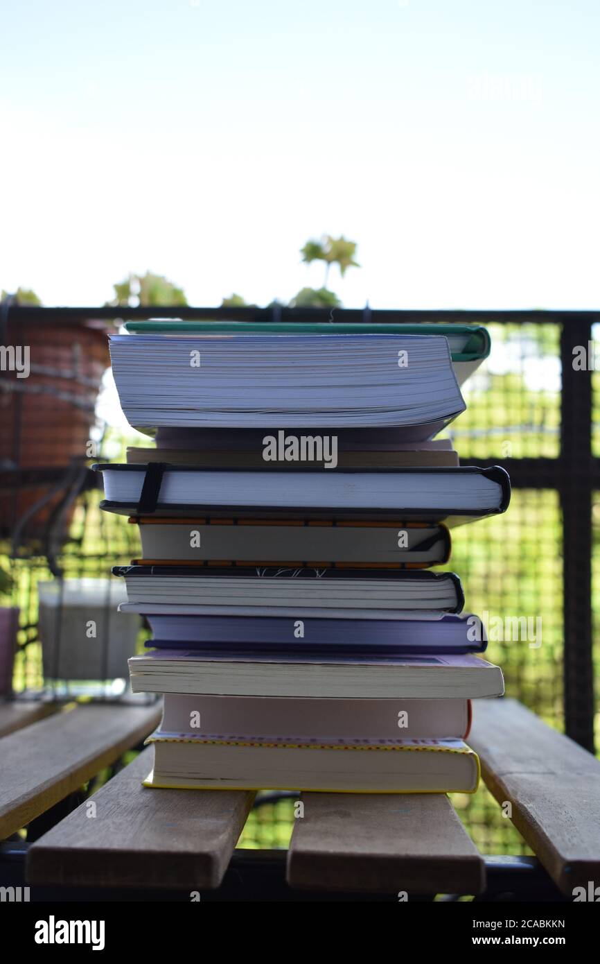 Vertical shot of a stack of books and notebooks on a shelf Stock Photo ...