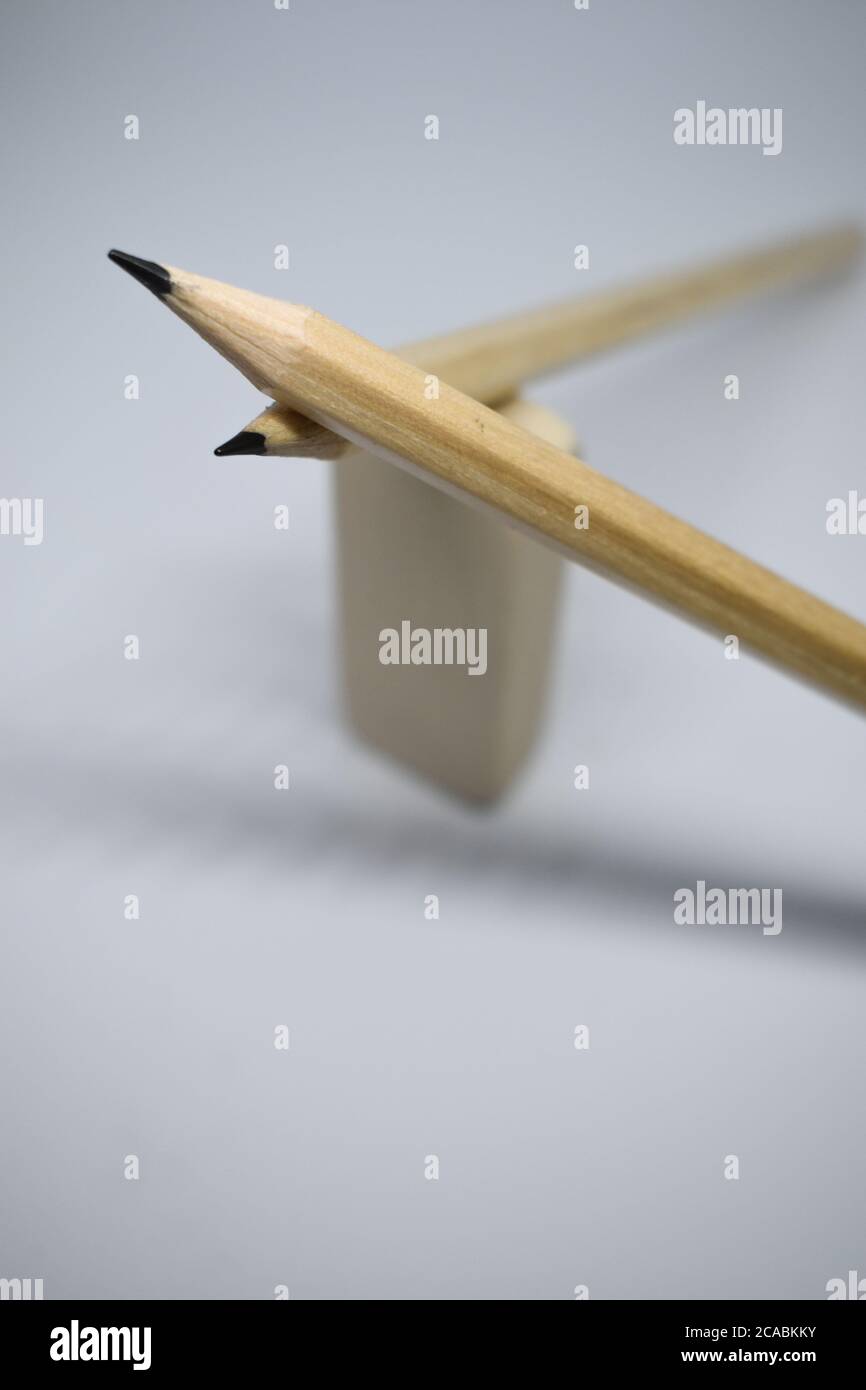Vertical closeup shot of pencils and an eraser on a white background ...