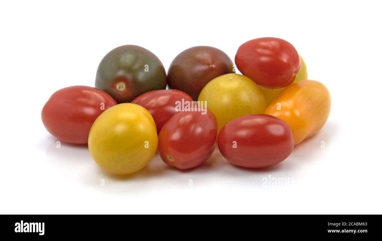 Small colorful tomatoes against white background Stock Photo - Alamy