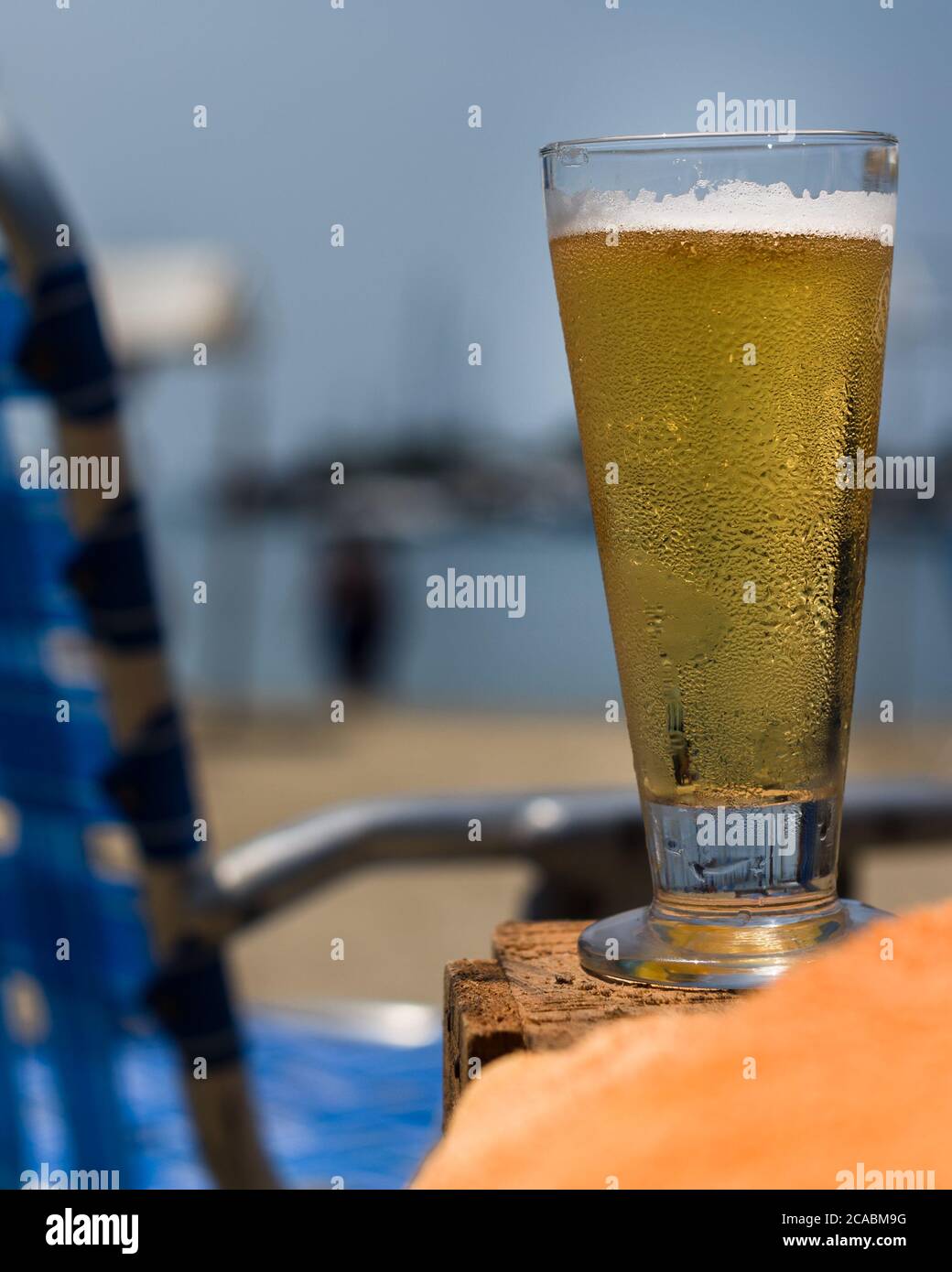Vertical selective focus shot of a glass of cold beer at a beach Stock ...