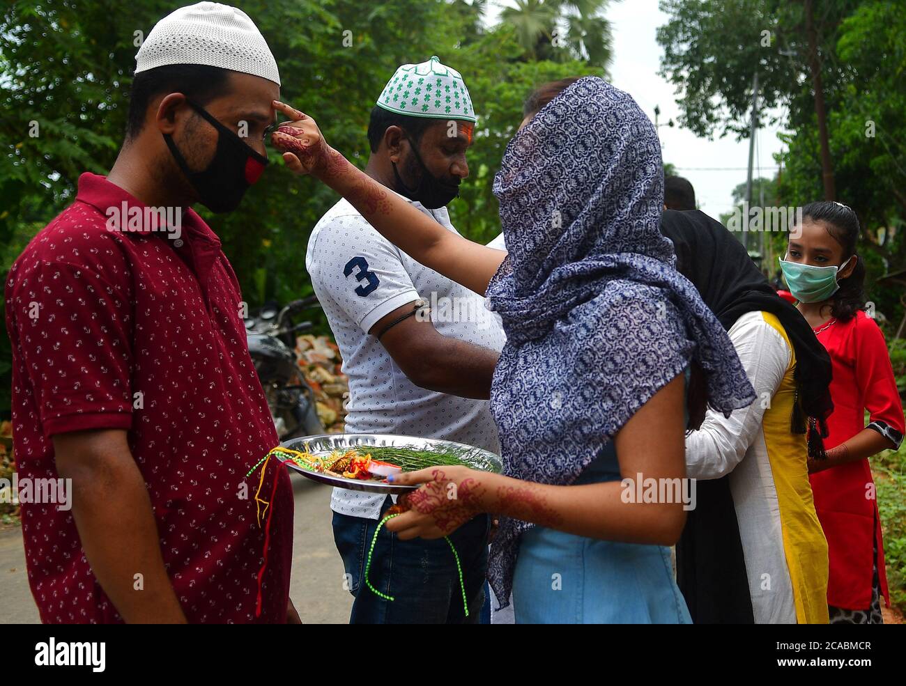 A Hindu girl ties a "Rakhi", a sacred thread, on the wrist of a Muslim ...