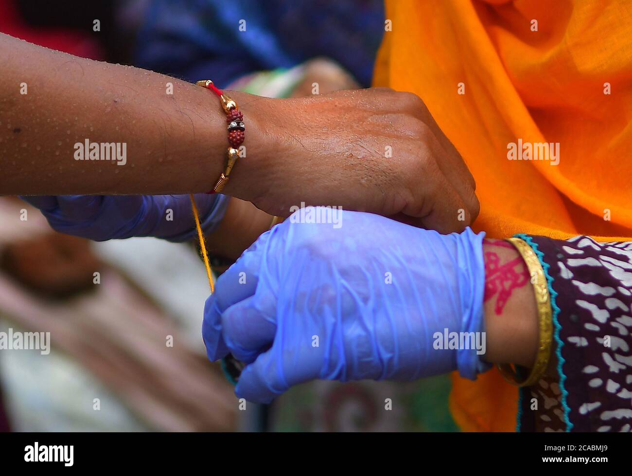 A Hindu girl ties a "Rakhi", a sacred thread, on the wrist of Indian ...