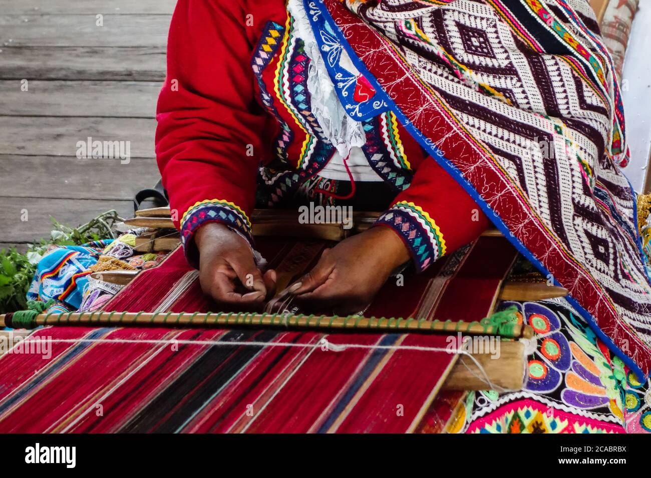High angle shot of a female in traditional clothes sewing under the ...