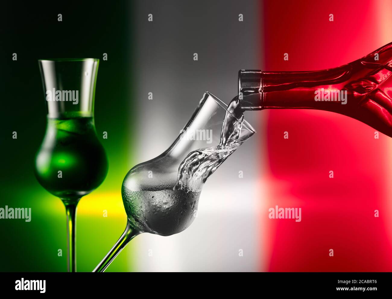 Steamed glass with tequila on a background of the Mexican flag. Pouring ...