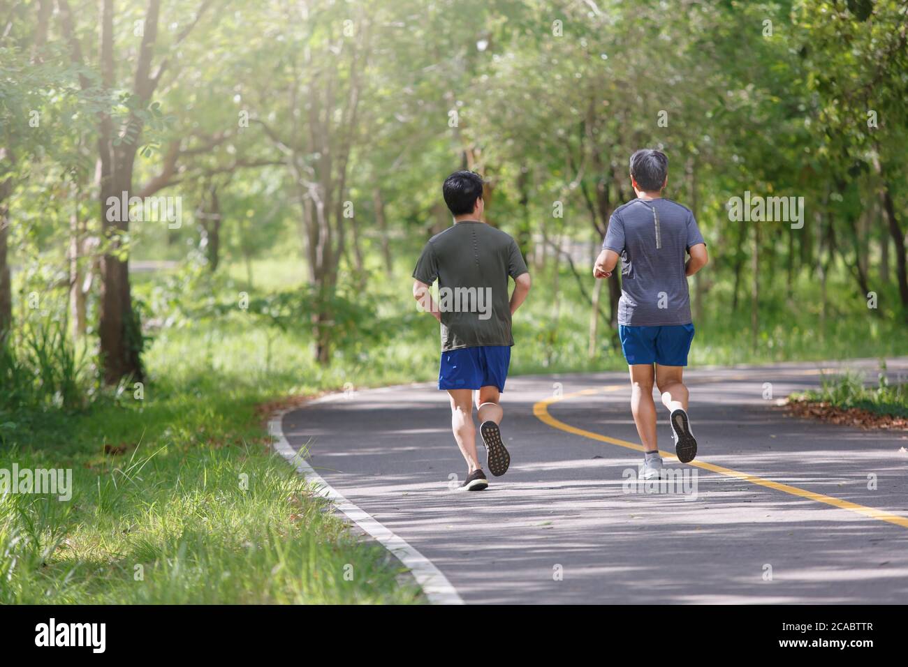 Father and adult son jogging on the park path Stock Photo - Alamy