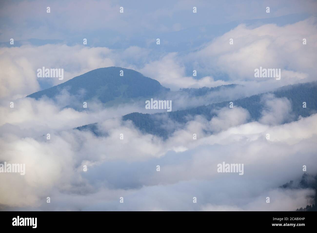 Fluffy morning clouds above mountain tops view. Climate, environment ...