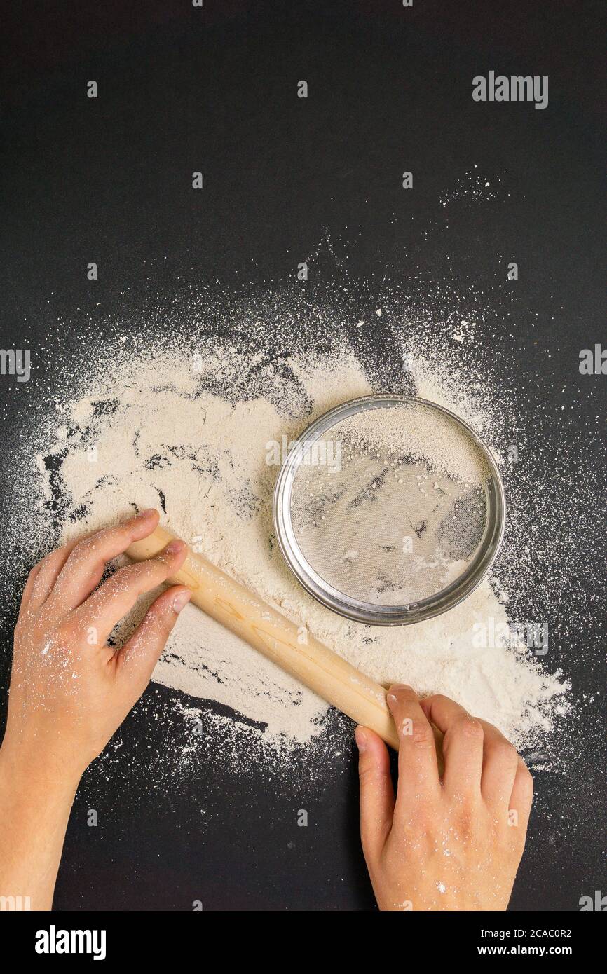 Male Baker sprinkle the dough with flour. The preparation of bread. The ...