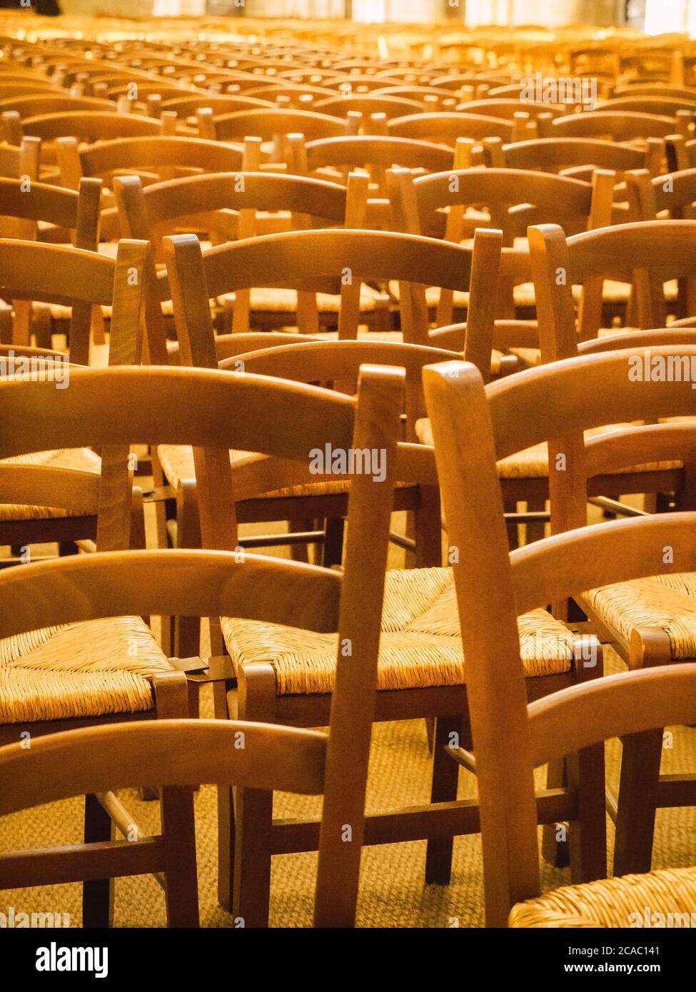 Rows of empty wooden chairs arranged next to each other Stock Photo - Alamy