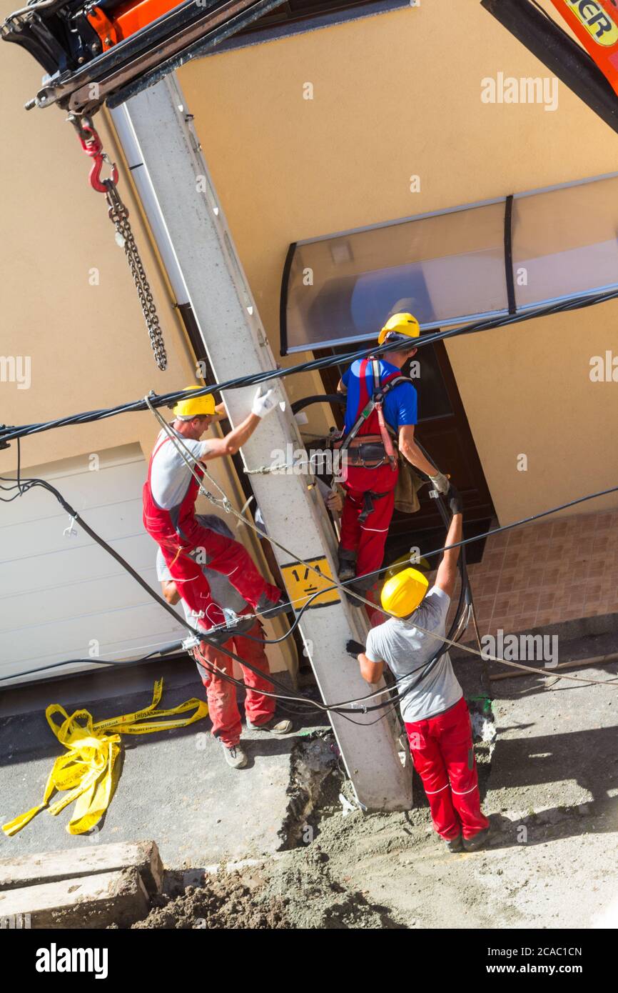 Process of installing new concrete electricity pylon in the street ...
