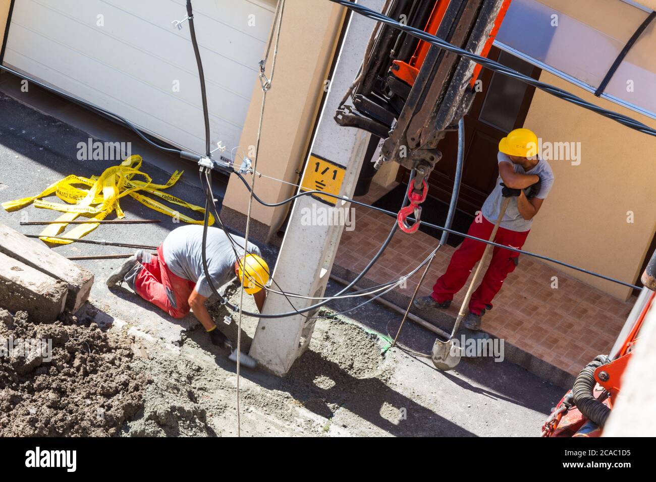 Process of installing new concrete electricity pylon in the street ...