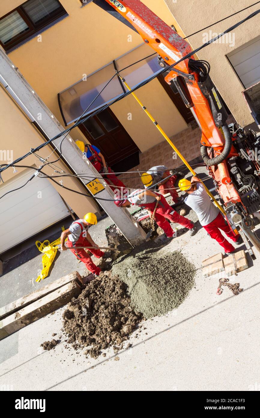 Process of installing new concrete electricity pylon in the street ...
