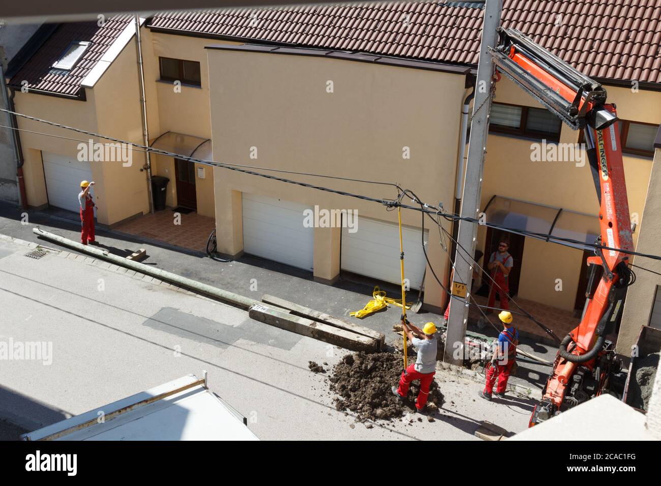 Process of installing new concrete electricity pylon in the street ...