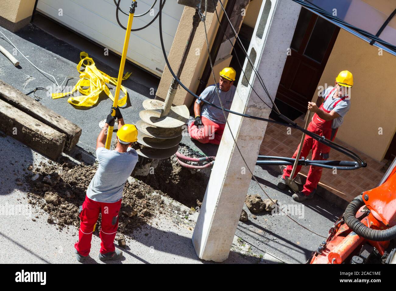 Process of installing new concrete electricity pylon in the street ...
