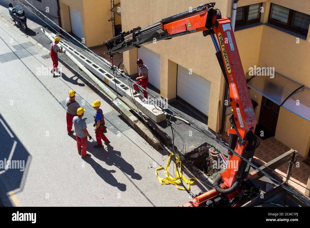 Process of installing new concrete electricity pylon in the street ...