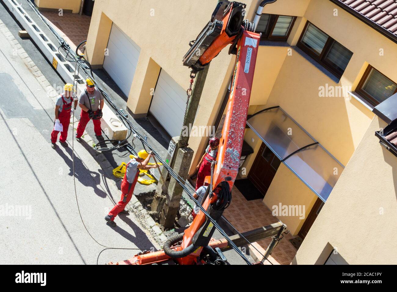 Process of installing new concrete electricity pylon in the street ...