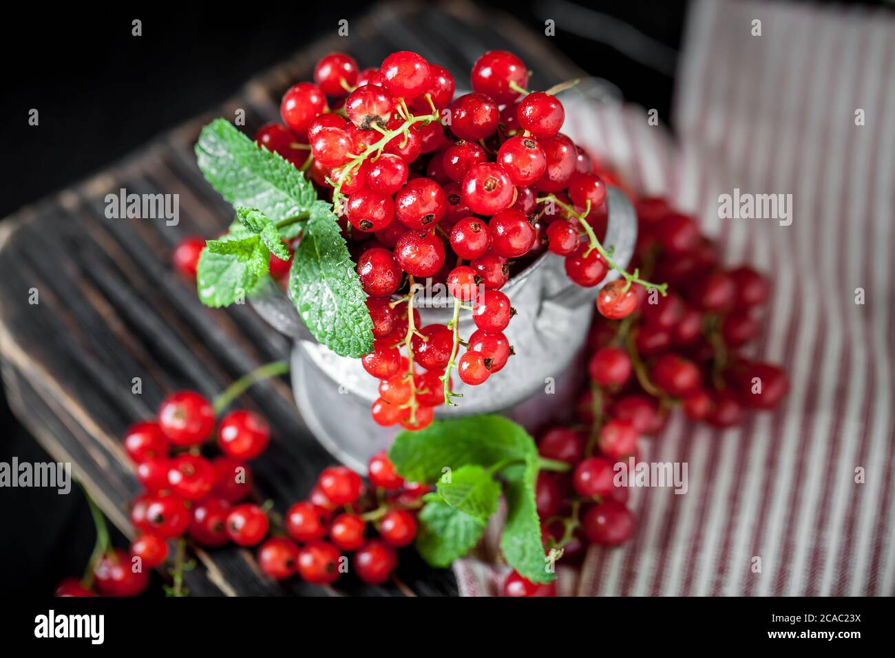 Fresh red currants in a Cup on a dark rustic wooden table. Background ...