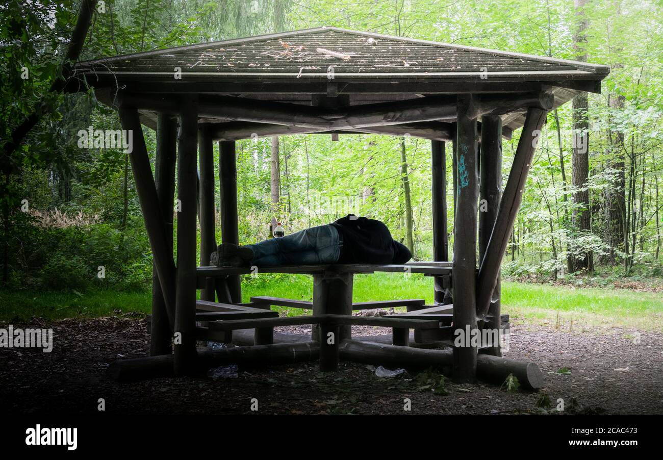 homeless man with alcohol sleeping in an abandoned forest shack Stock ...
