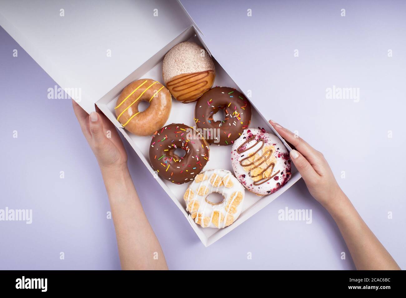 Overhead shot of a female holding a white box of different types of ...