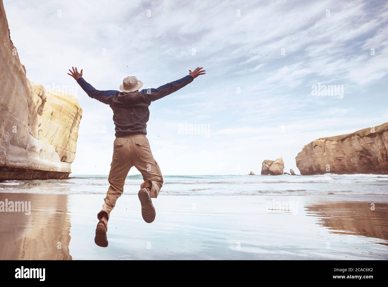 Jumping man on sunset beach Stock Photo - Alamy