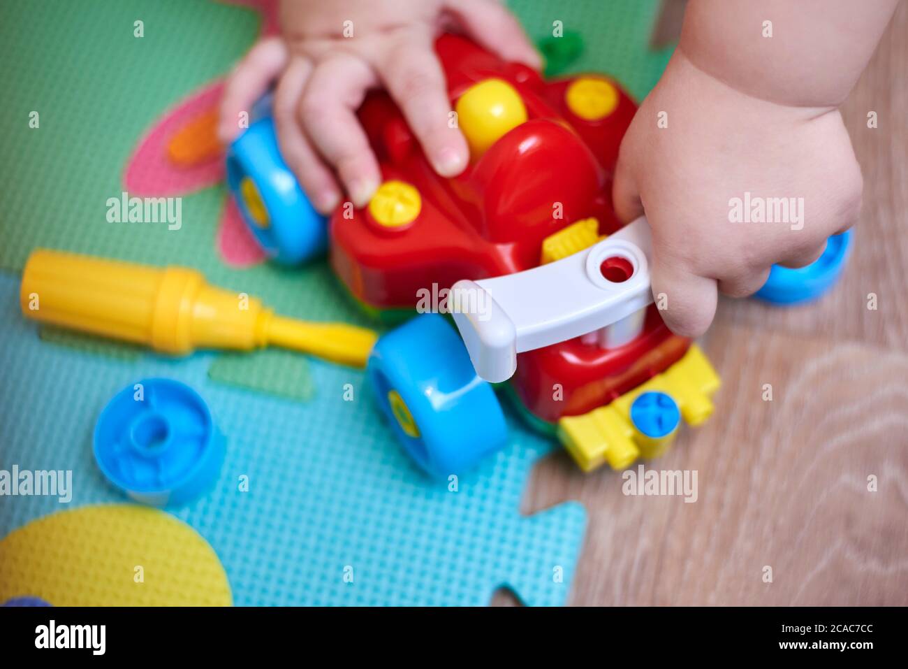 The boy plays with a car that can be disassembled, educational toys for ...