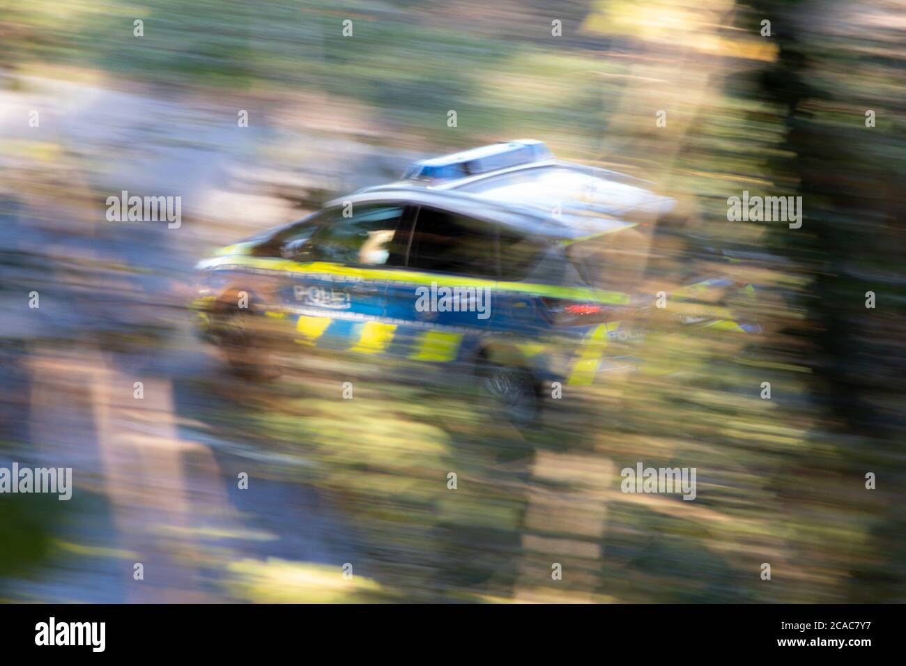 German police car in motion, taken through trees, blurred Stock Photo ...