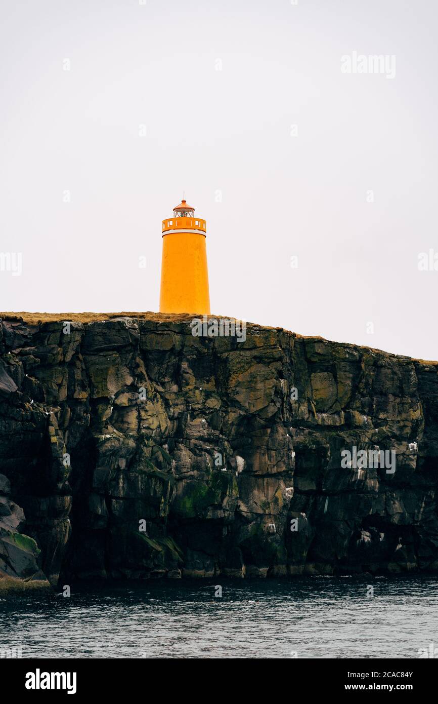A huge orange lighthouse on a cliff in Iceland Stock Photo - Alamy