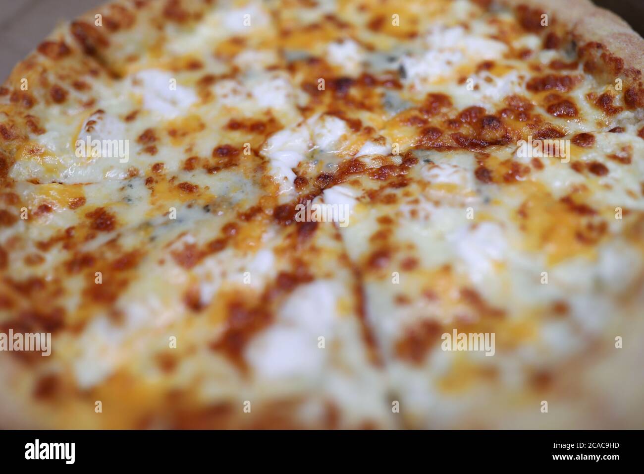 A large traditional pizza cut into slices close up Stock Photo - Alamy