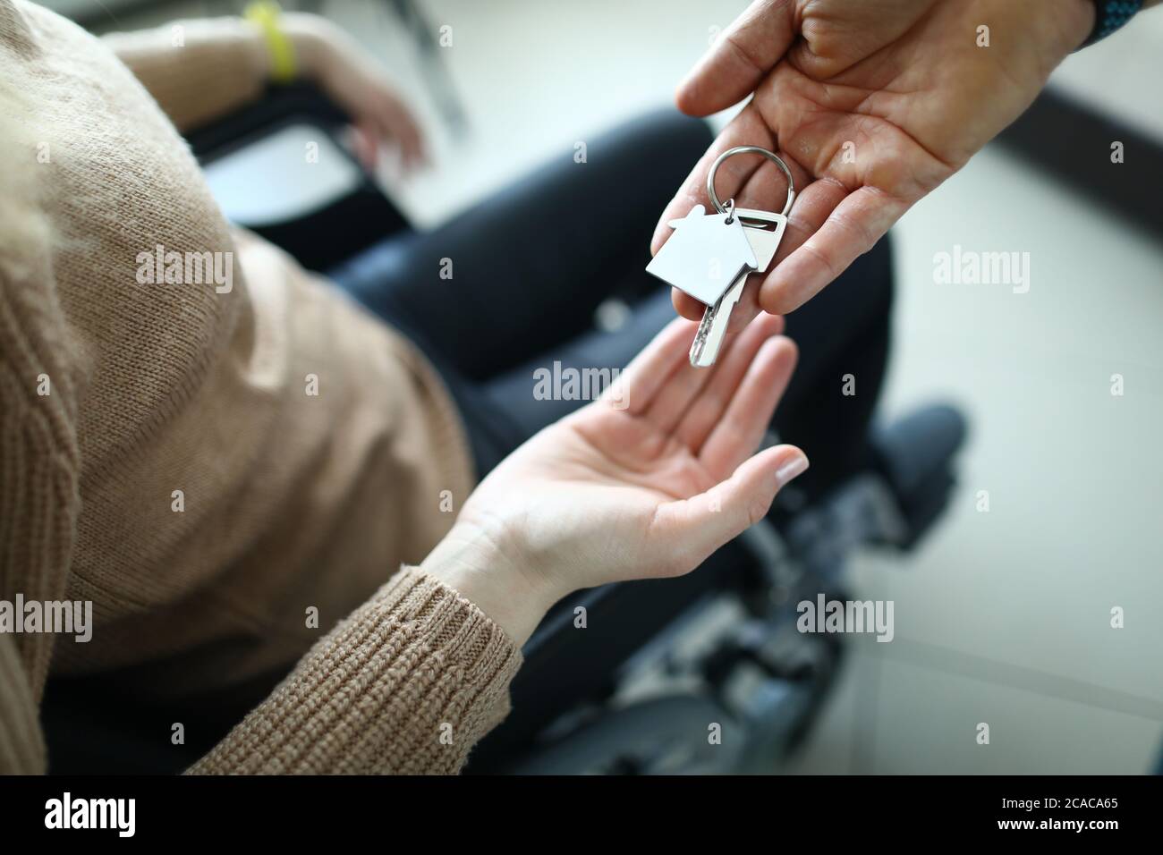 Young woman on wheelchair receiving house keys Stock Photo - Alamy