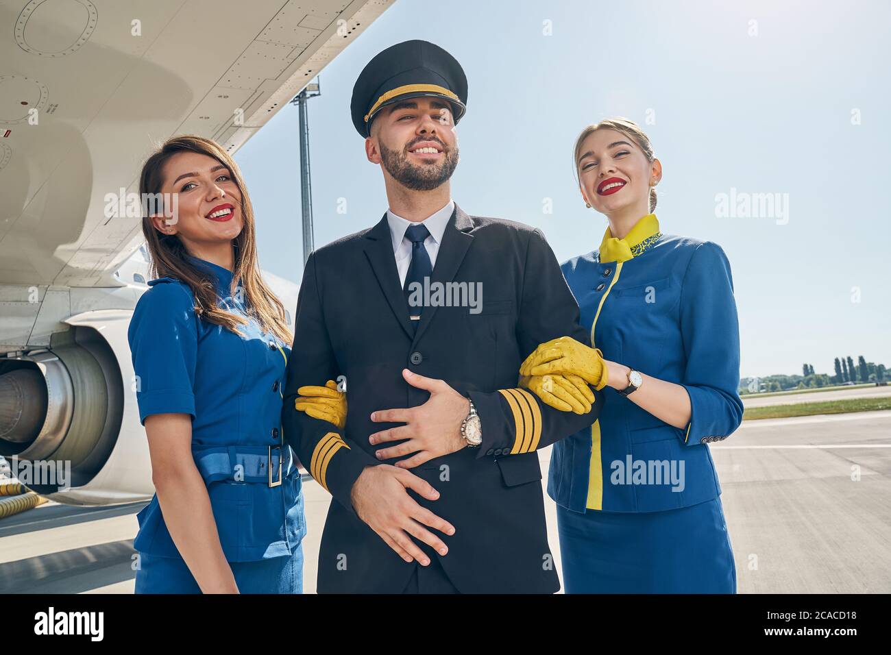 Modern young cabin crew smiling at the camera Stock Photo - Alamy