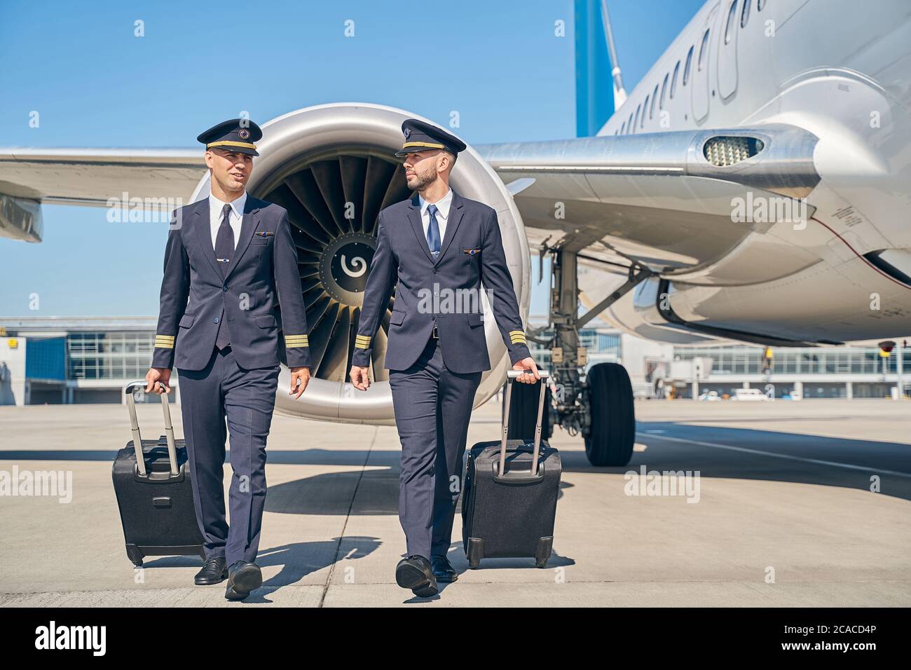 Two airline male pilots and their baggage Stock Photo - Alamy