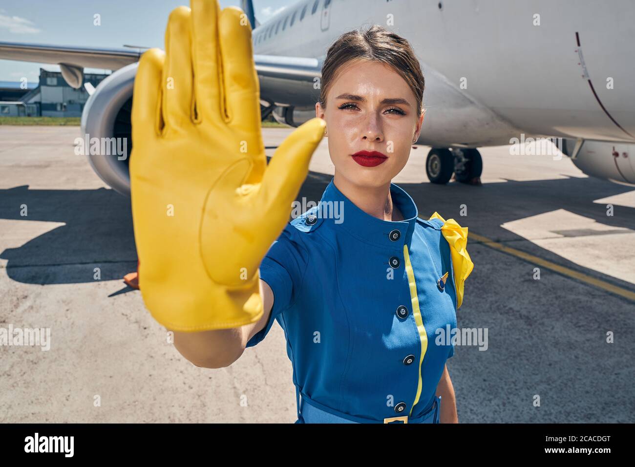 Female flight attendant showing a stop sign Stock Photo - Alamy