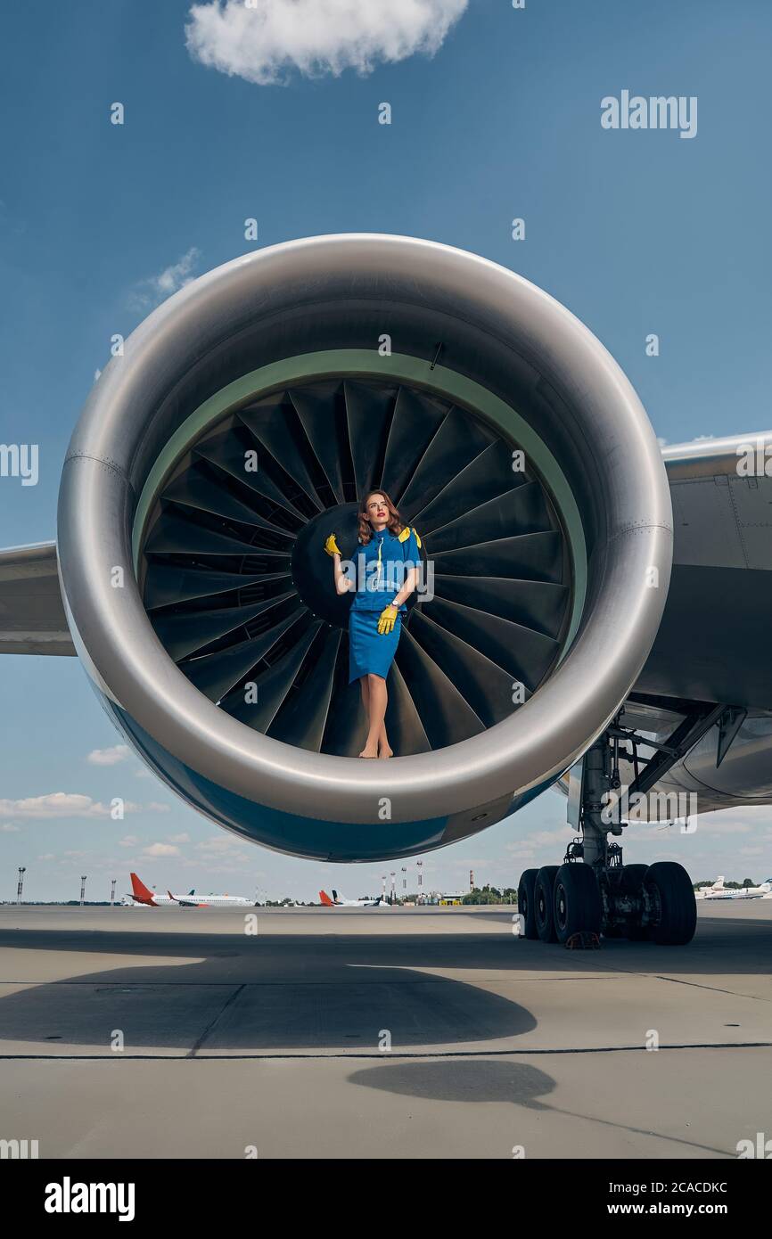 Serious pretty lady standing inside the aeroengine Stock Photo - Alamy