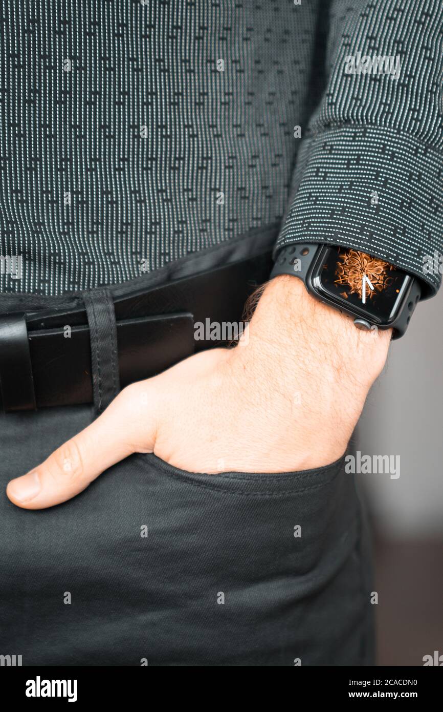 Vertical shot of a smartwatch with a display fire background on a man's ...