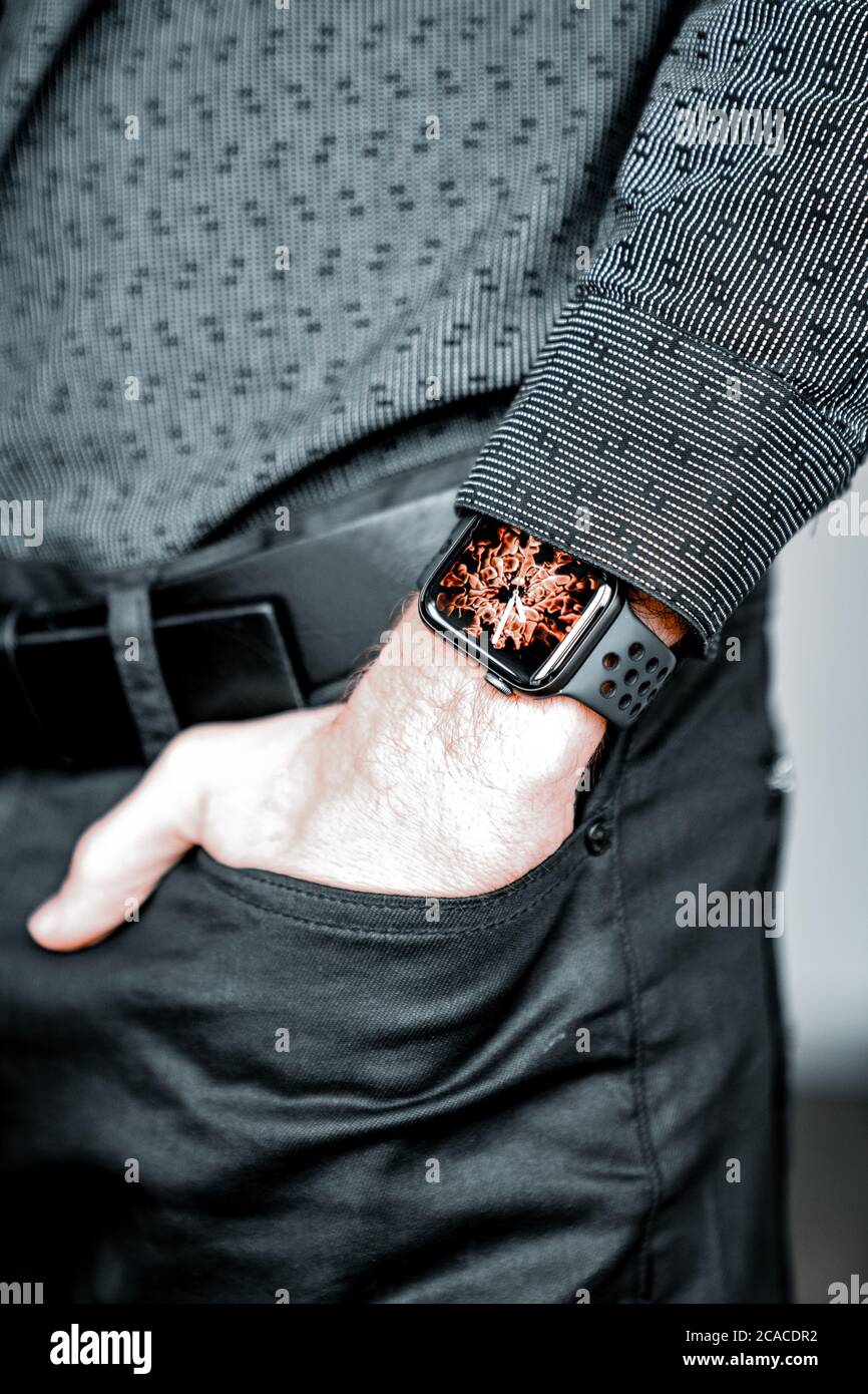 Vertical shot of a smartwatch with a display fire background on a man's ...