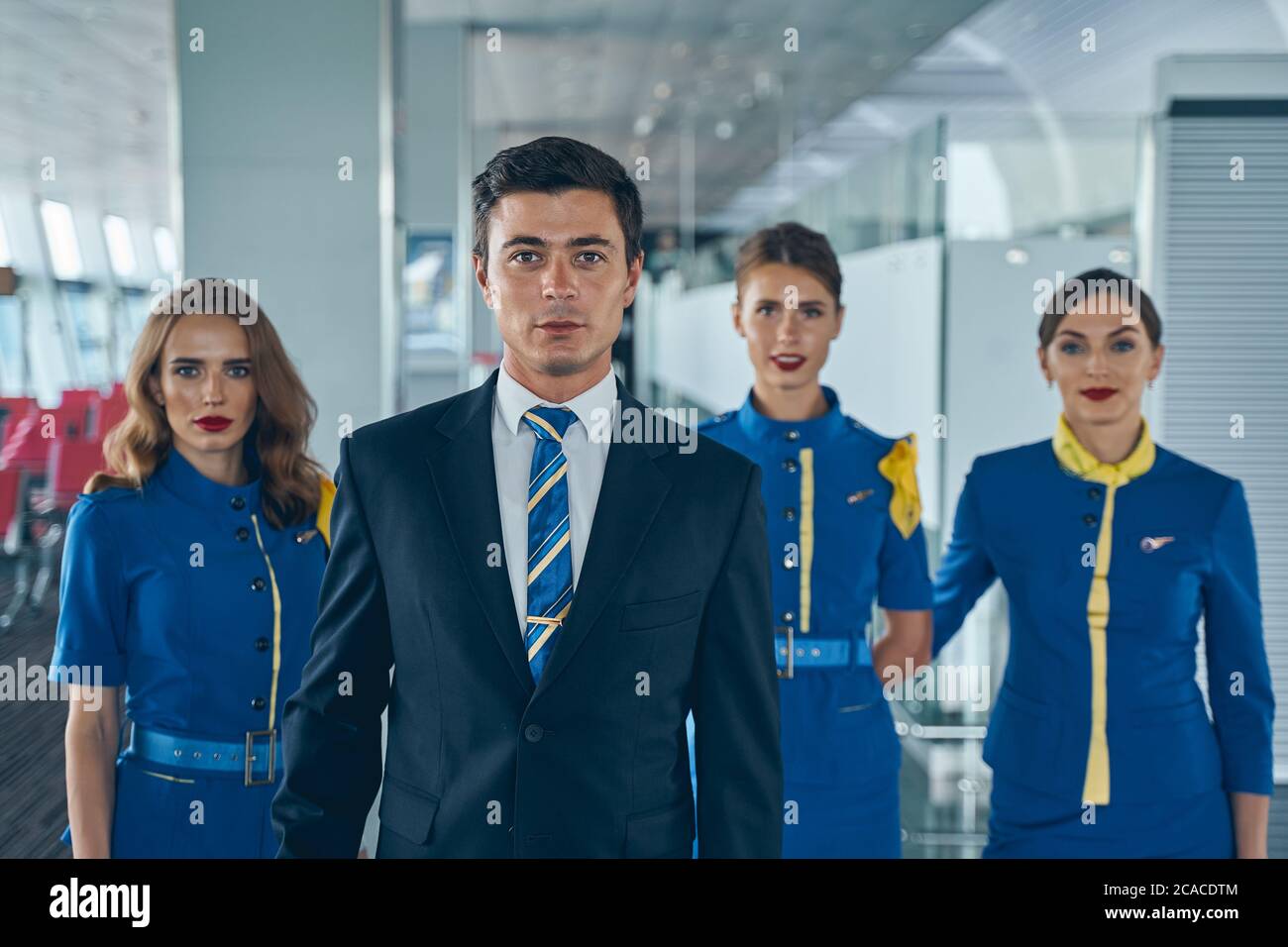 Young cabin crew posing for the camera indoors Stock Photo - Alamy