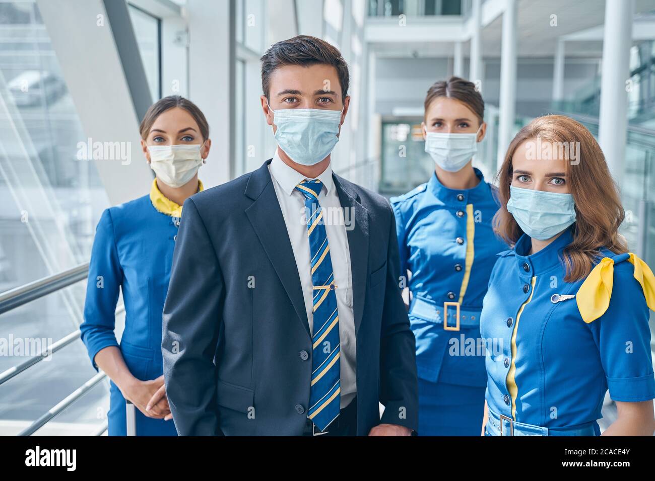 Serious flight attendants staring in front of them Stock Photo - Alamy