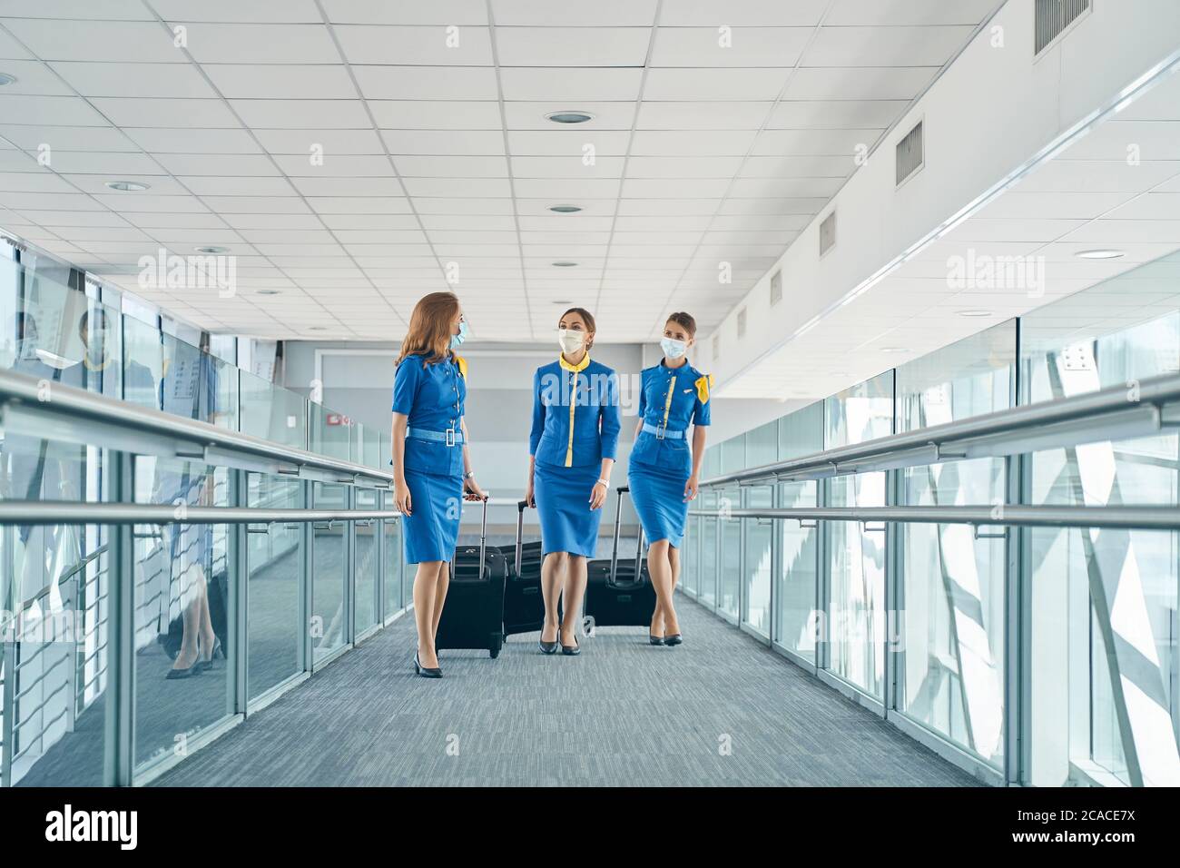 Three airline female employees standing at the airport Stock Photo - Alamy
