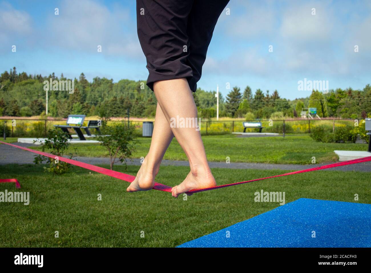 closeup feet walking over a slackline tightrope at the park Stock Photo ...