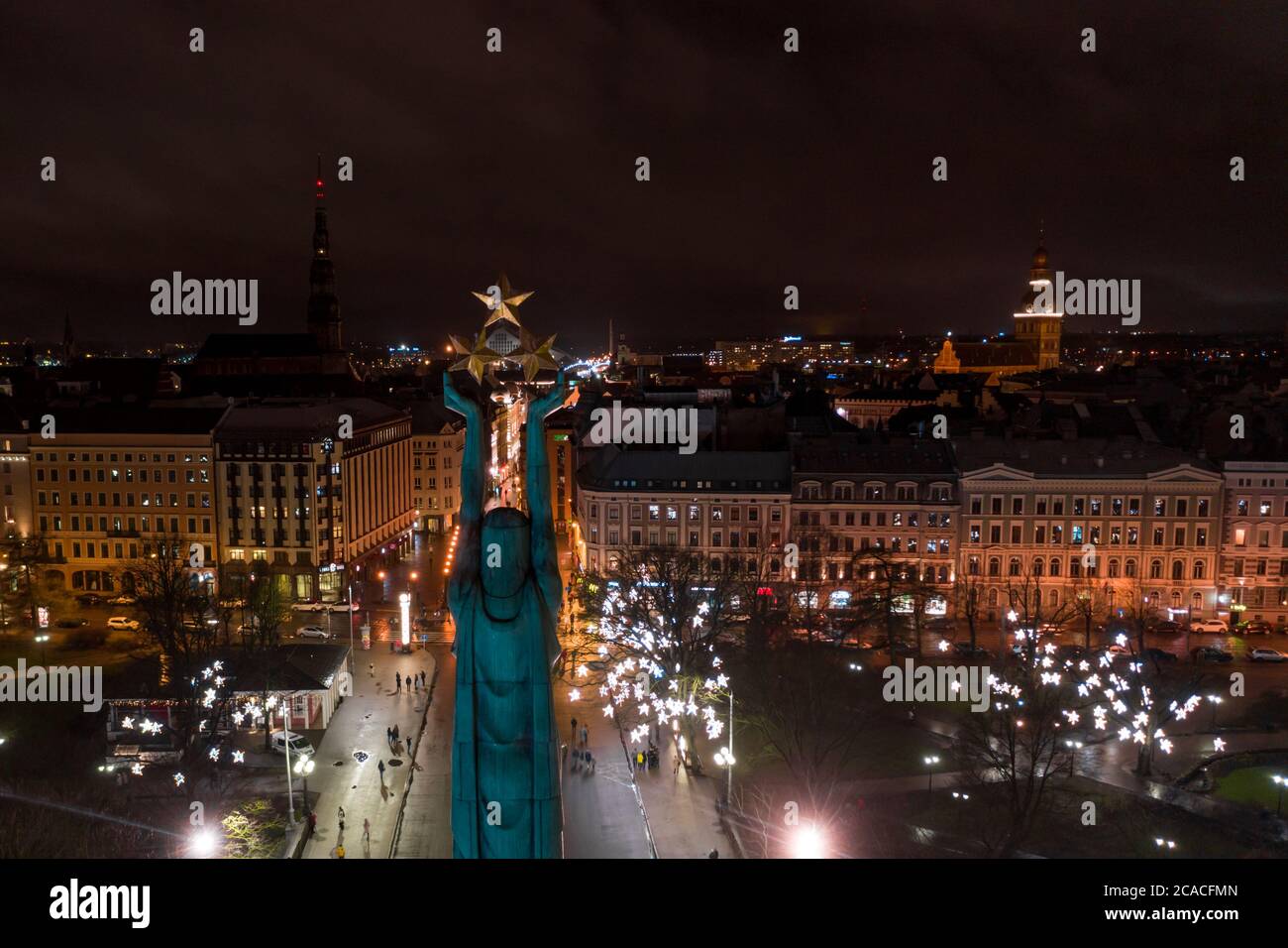 Night shot of the top of Freedom Monument on background of Riga, Latvia ...