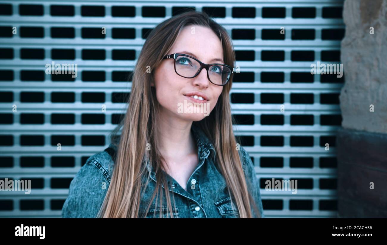 Portrait young woman with glasses looking around and thinking on city ...