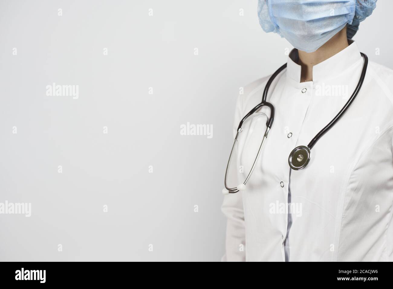 Doctor in a white uniform and face mask with a stethoscope Stock Photo ...