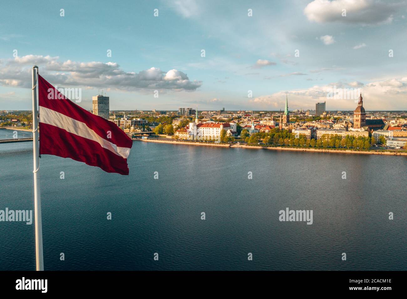 Aerial shot of Riga city with a big Latvian flag in the foreground at ...