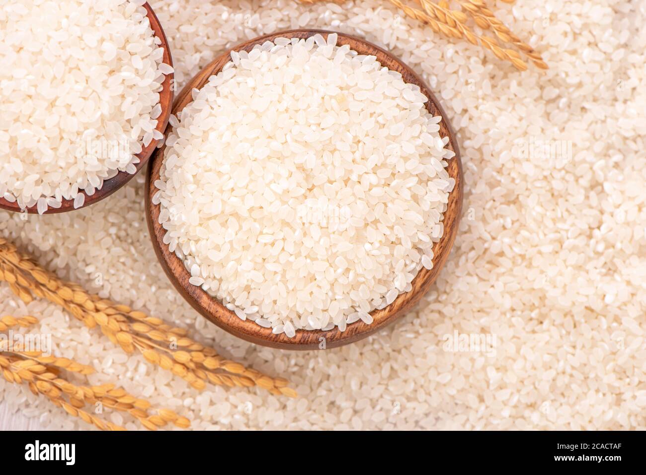 Raw rice in a bowl and full frame in the white background table, top ...