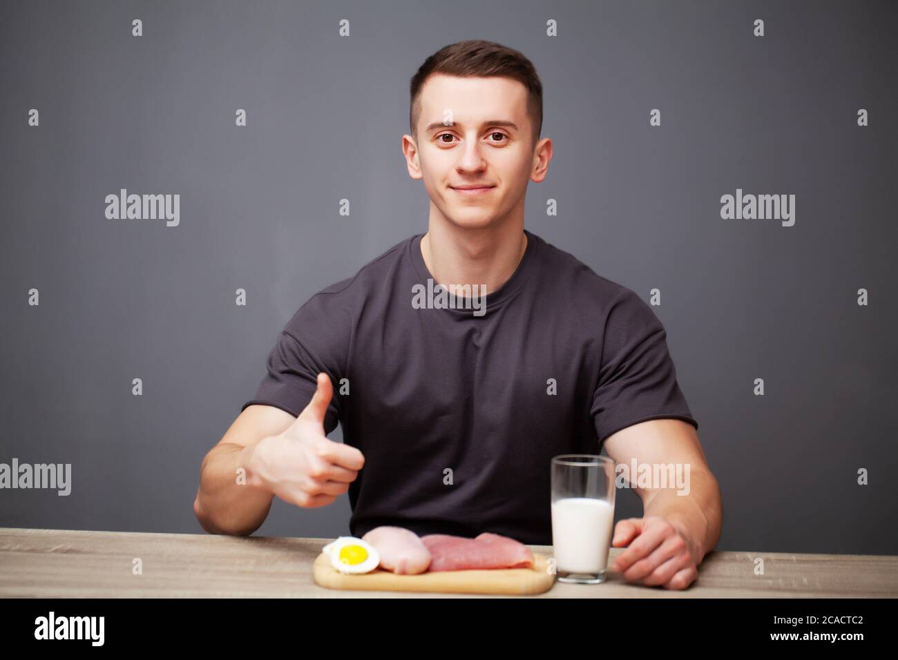 Shaped and healthy man holding a fresh meal board with meat Stock Photo ...