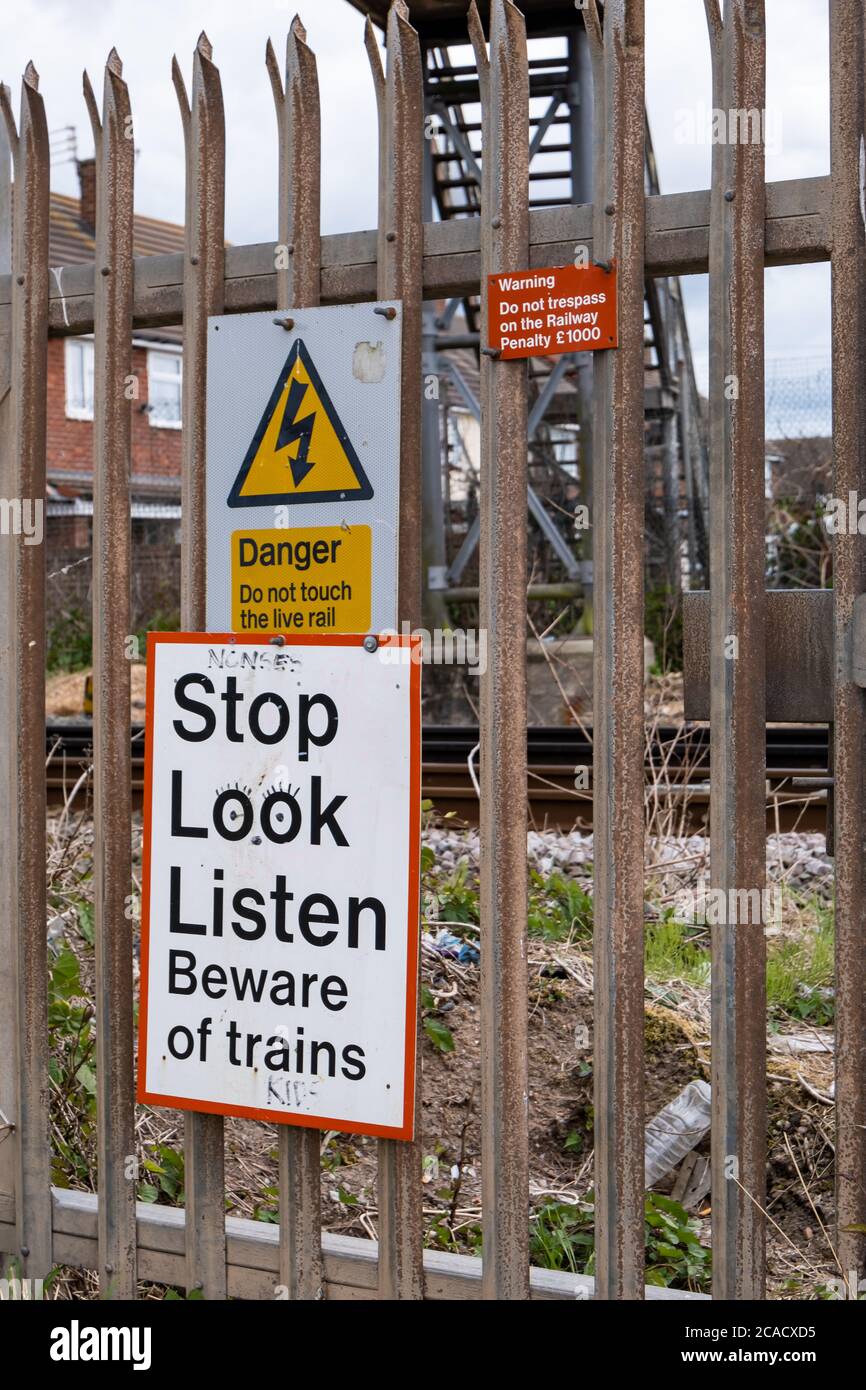 Signs on fence warning of dangers of nearby railway line in Moreton ...