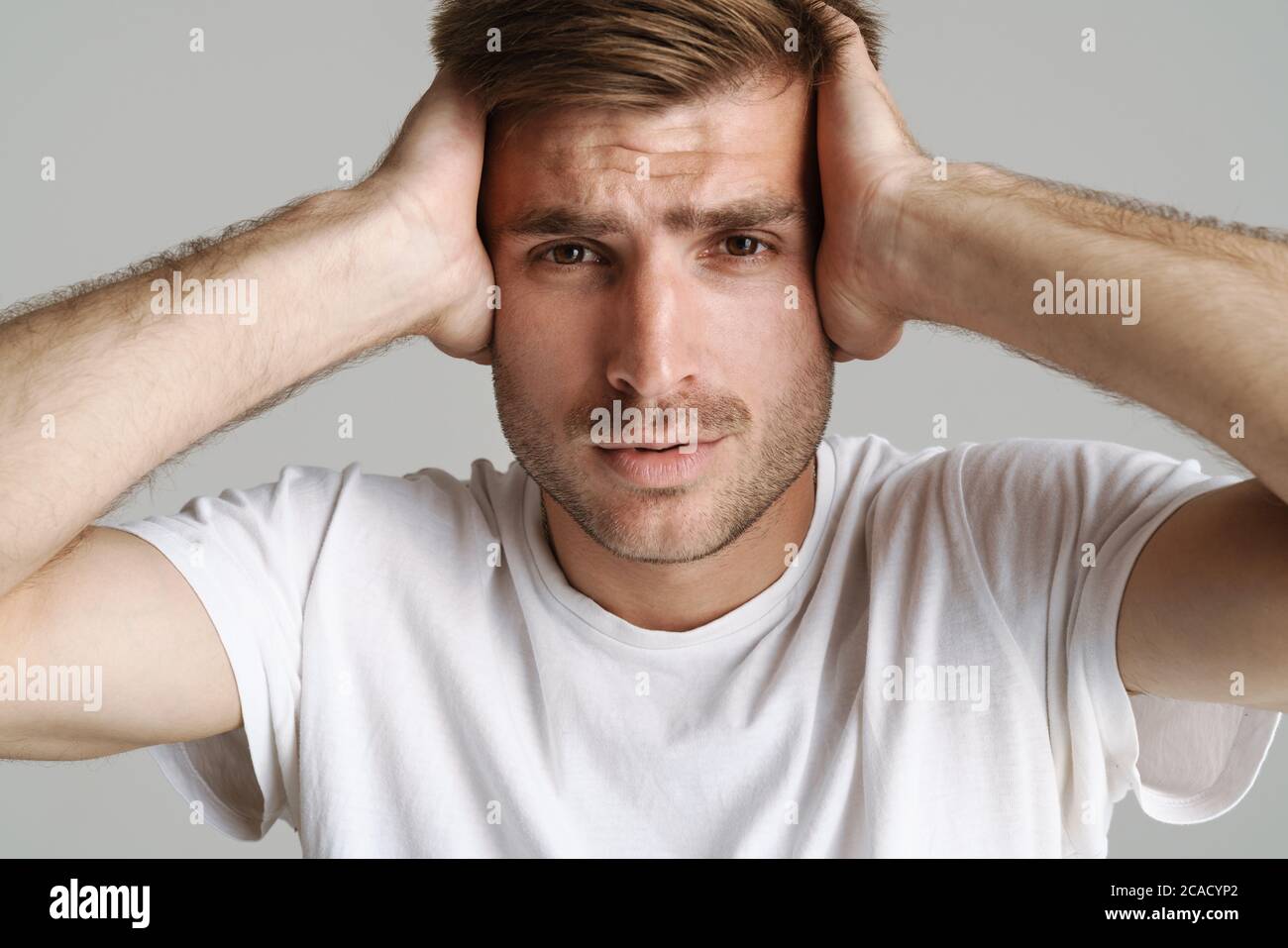 Portrait of redhead masculine man looking at camera while grabbing his ...