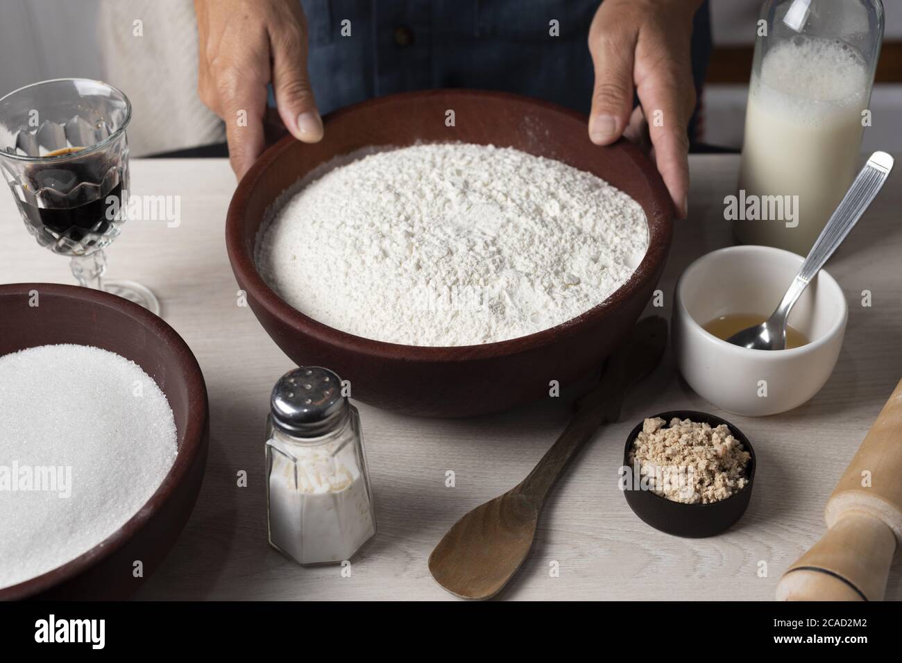 Closeup shot of bowl full of flour with person holding the bowl and ...