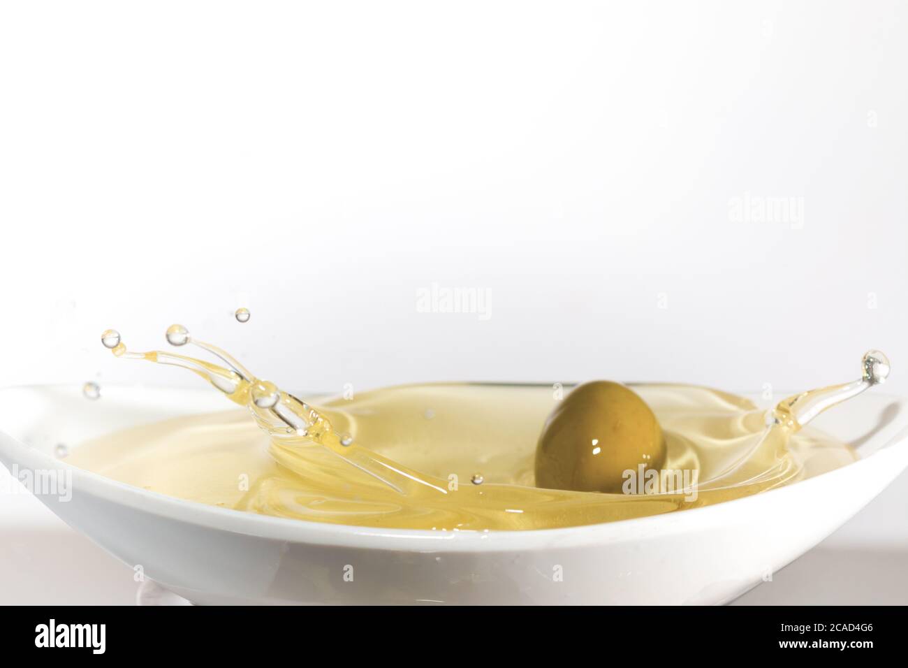 Olive oil falling into the olives and forming a splash Stock Photo - Alamy